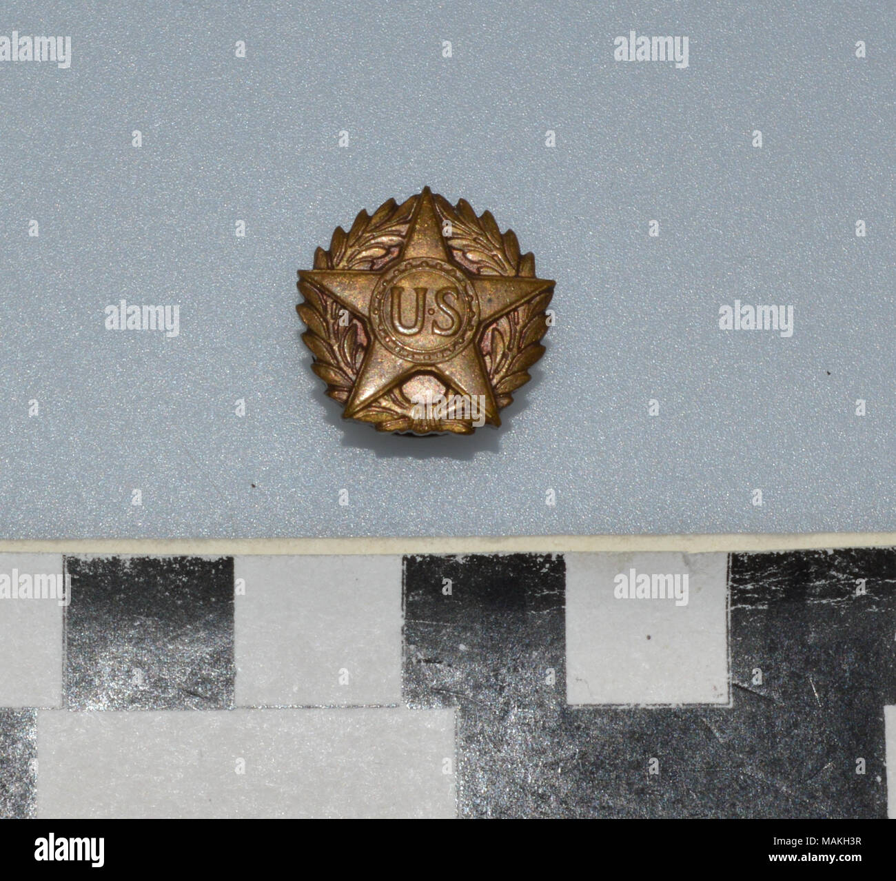 Small round brass American Legion pin featuring the letters 'US' in a ...