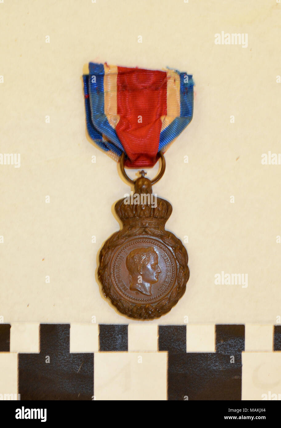 Bronze medal in shape of laurel wreath with crown; obverse has relief ...