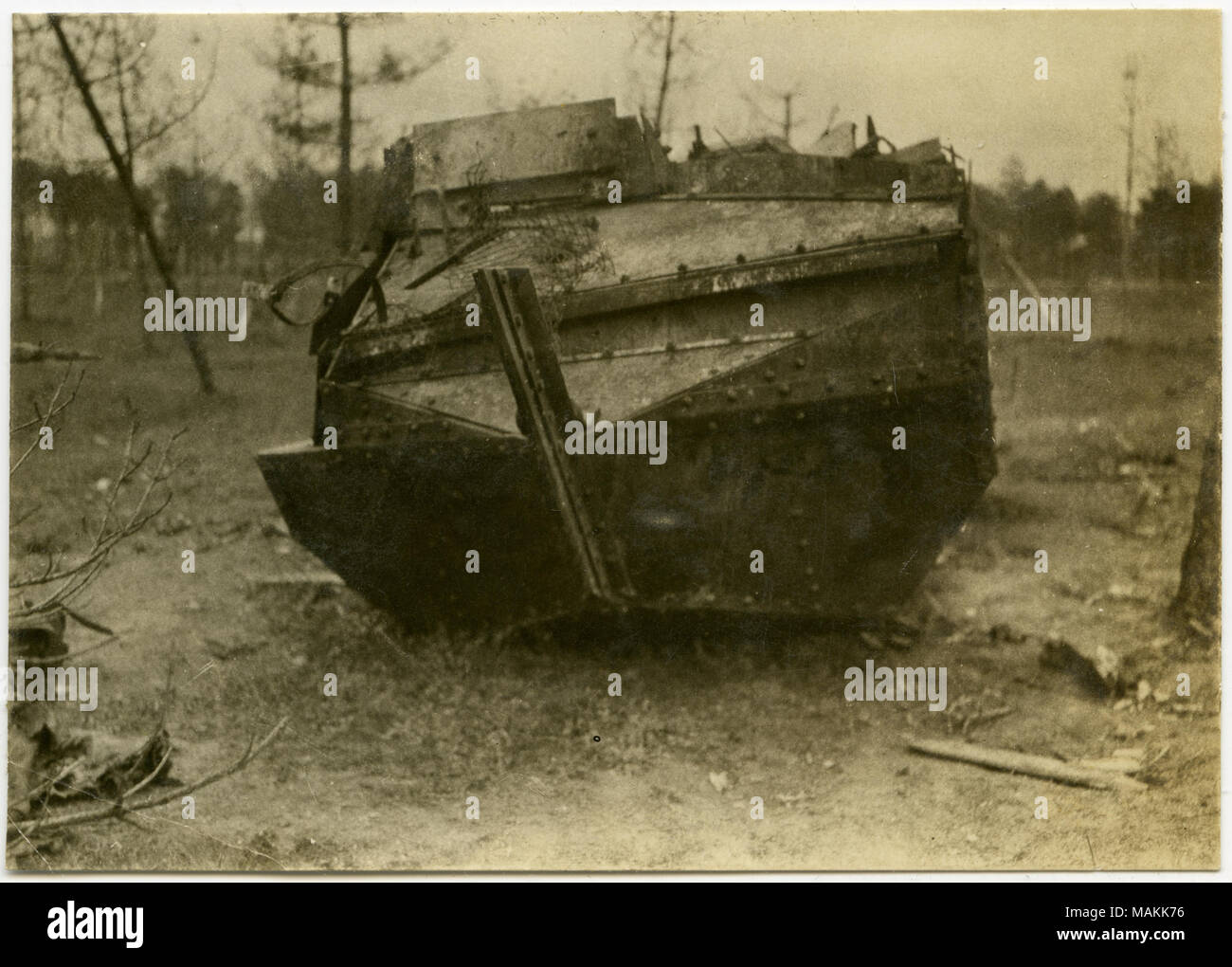 Horizontal, sepia photograph showing a heavily damaged tank, viewed ...