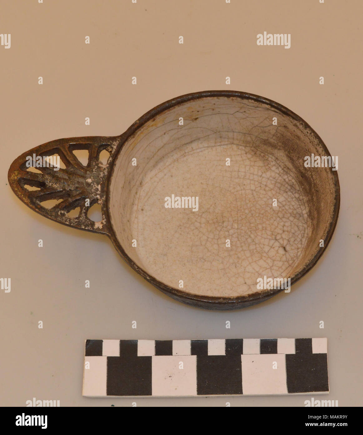 Cast iron porringer with a reticulated handle and inner lining of white ...