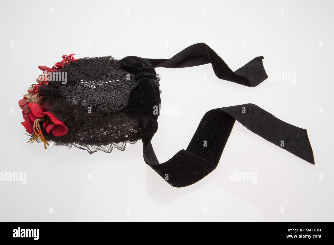 Woman's black bonnet with red flowers and black velvet tails. Title ...