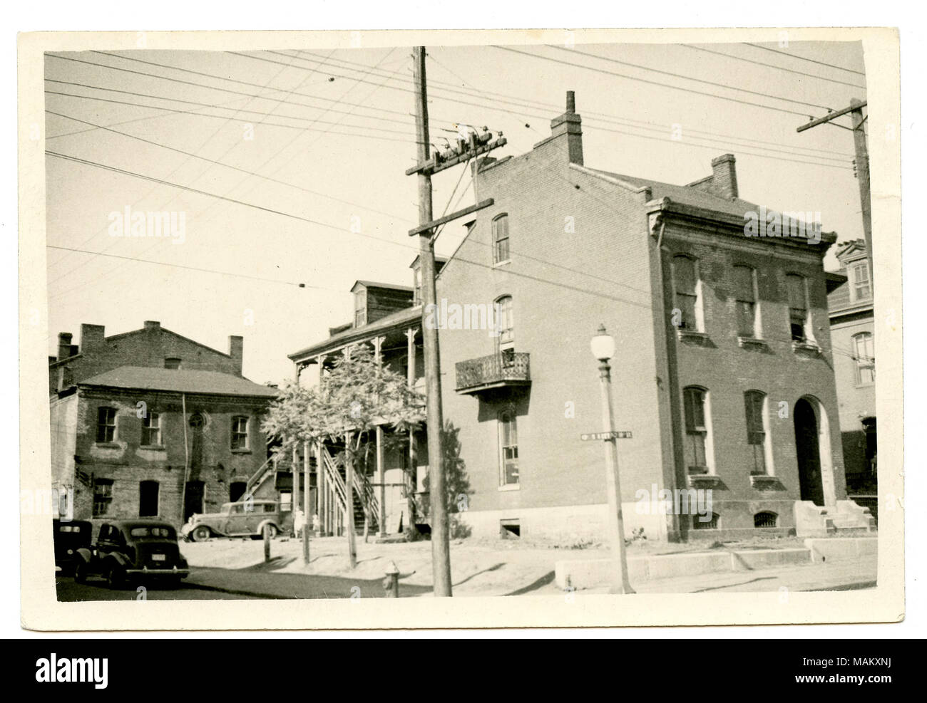 Horizontal, black and white photograph of a three story brick residence ...