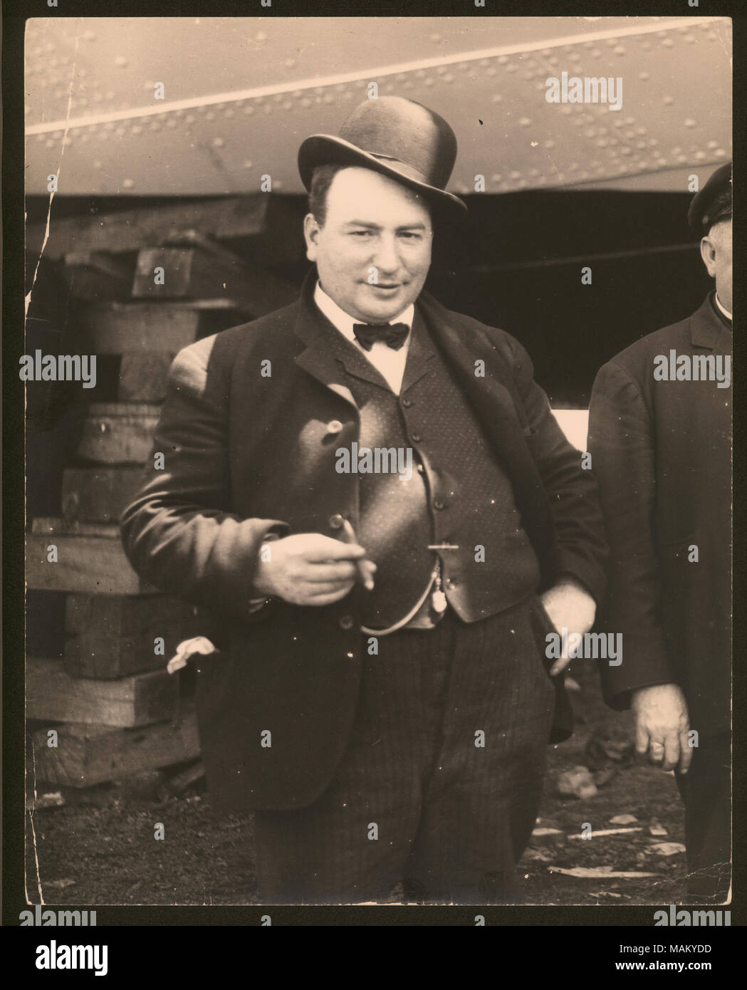 Vertical, black and white photograph of a man in a derby hat and bow ...