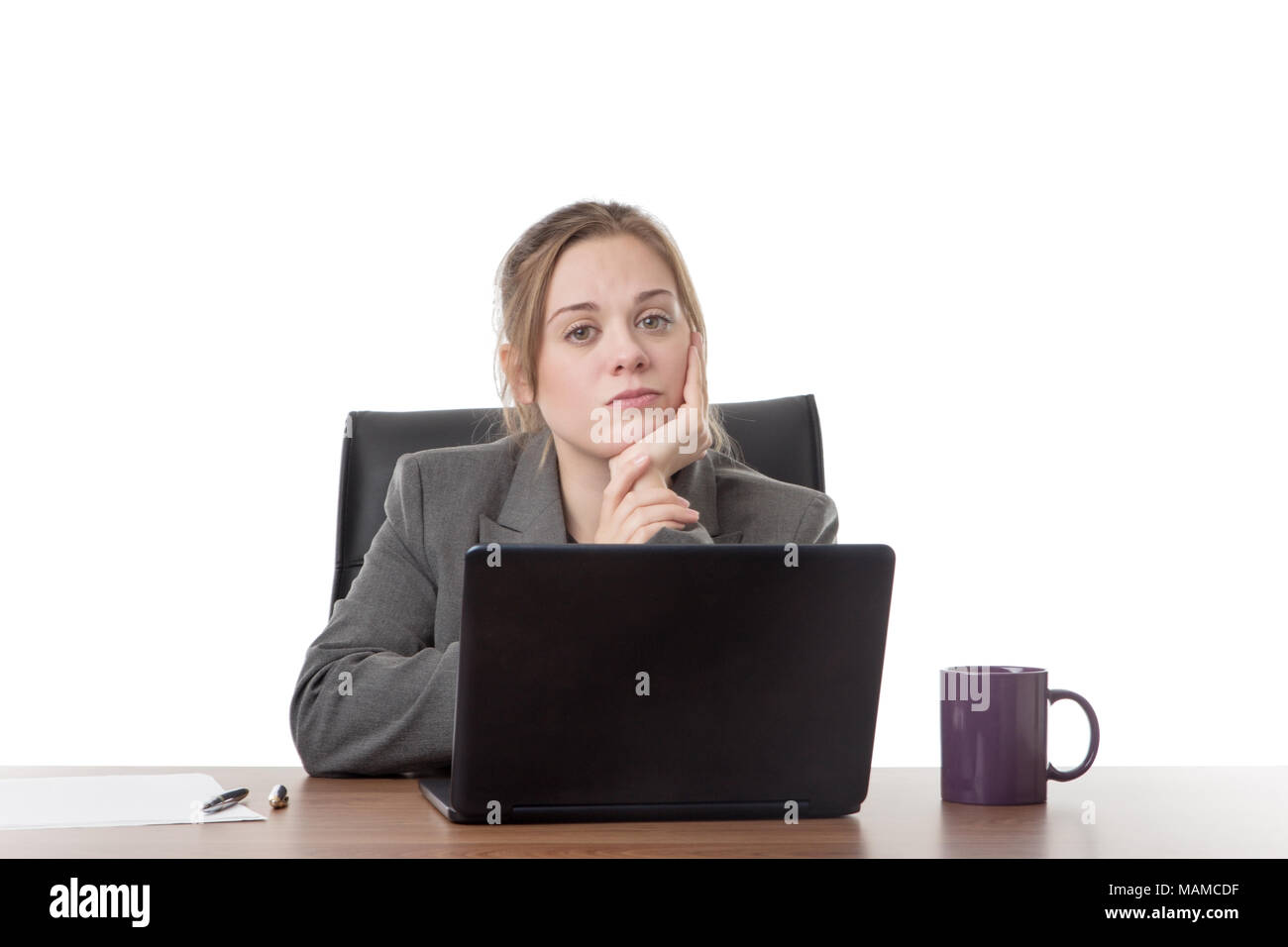 business woman sitting a a desk with a laptop computer in front of her ...