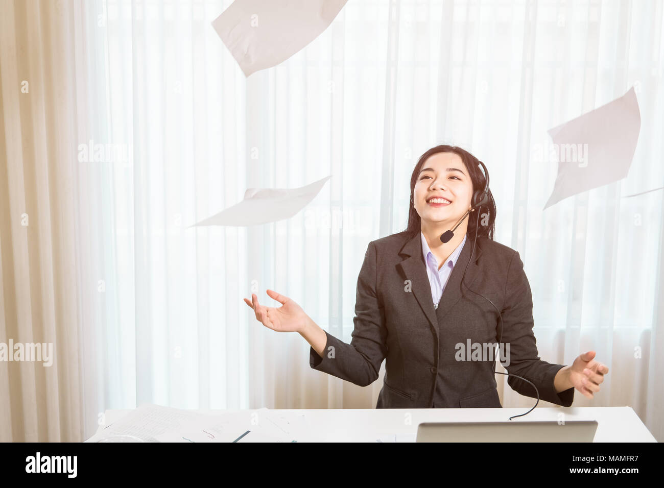 Young beautiful Asian business woman throwing papers up in the air for ...