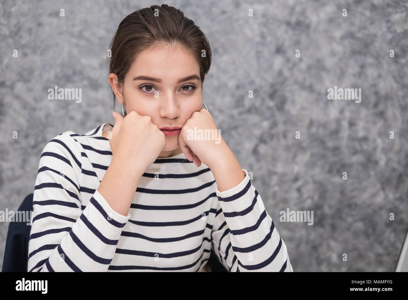 Beautiful young woman looking at a computer screen and thinking at the ...