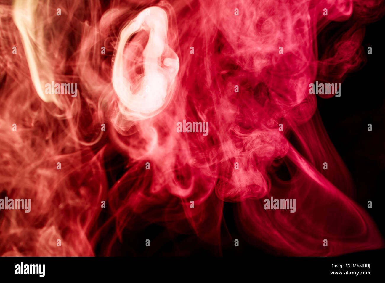 Multi-colored smoke with clubs of red and pink on a black isolated ...