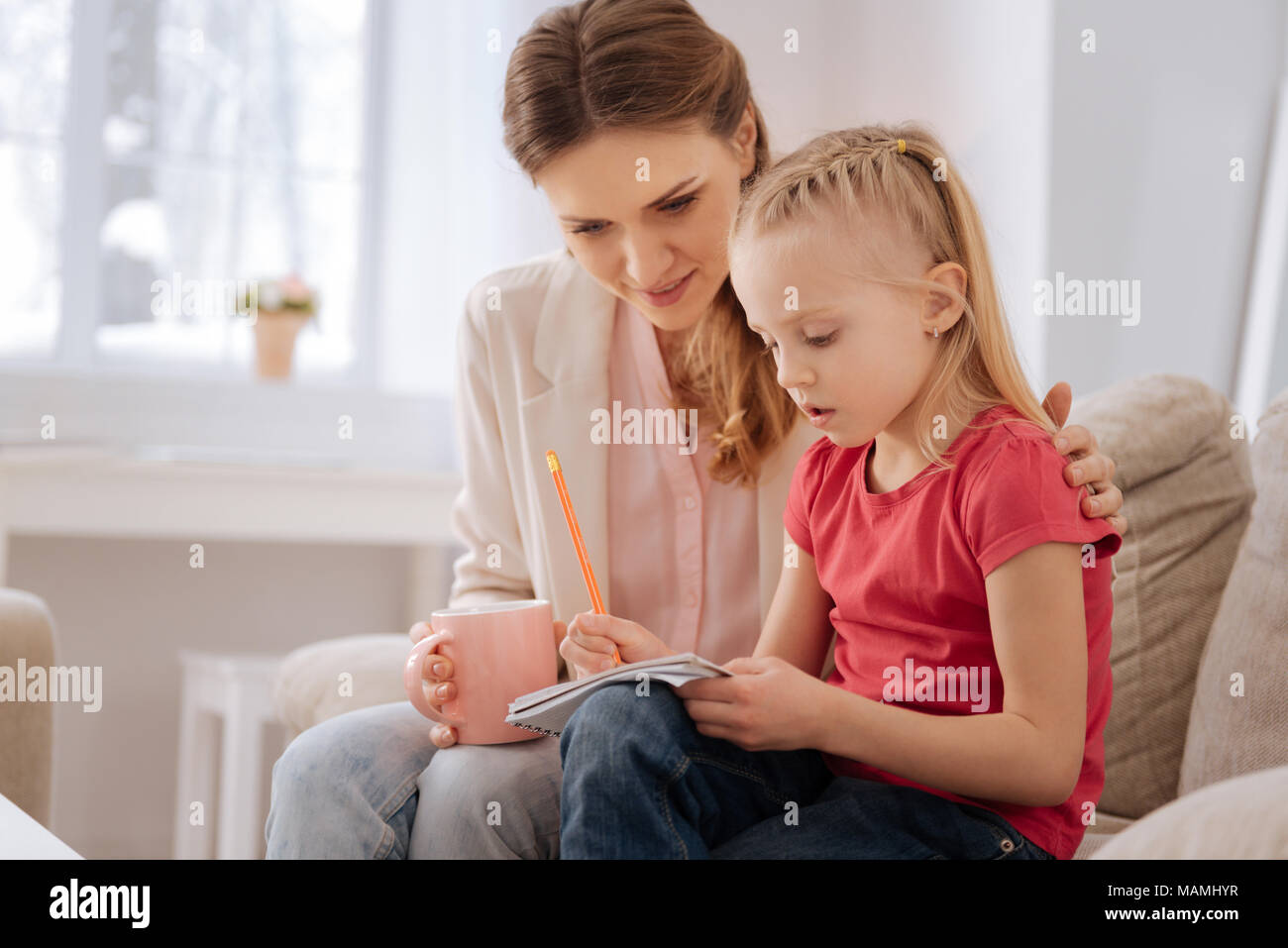Nice pleasant girl taking notes Stock Photo - Alamy