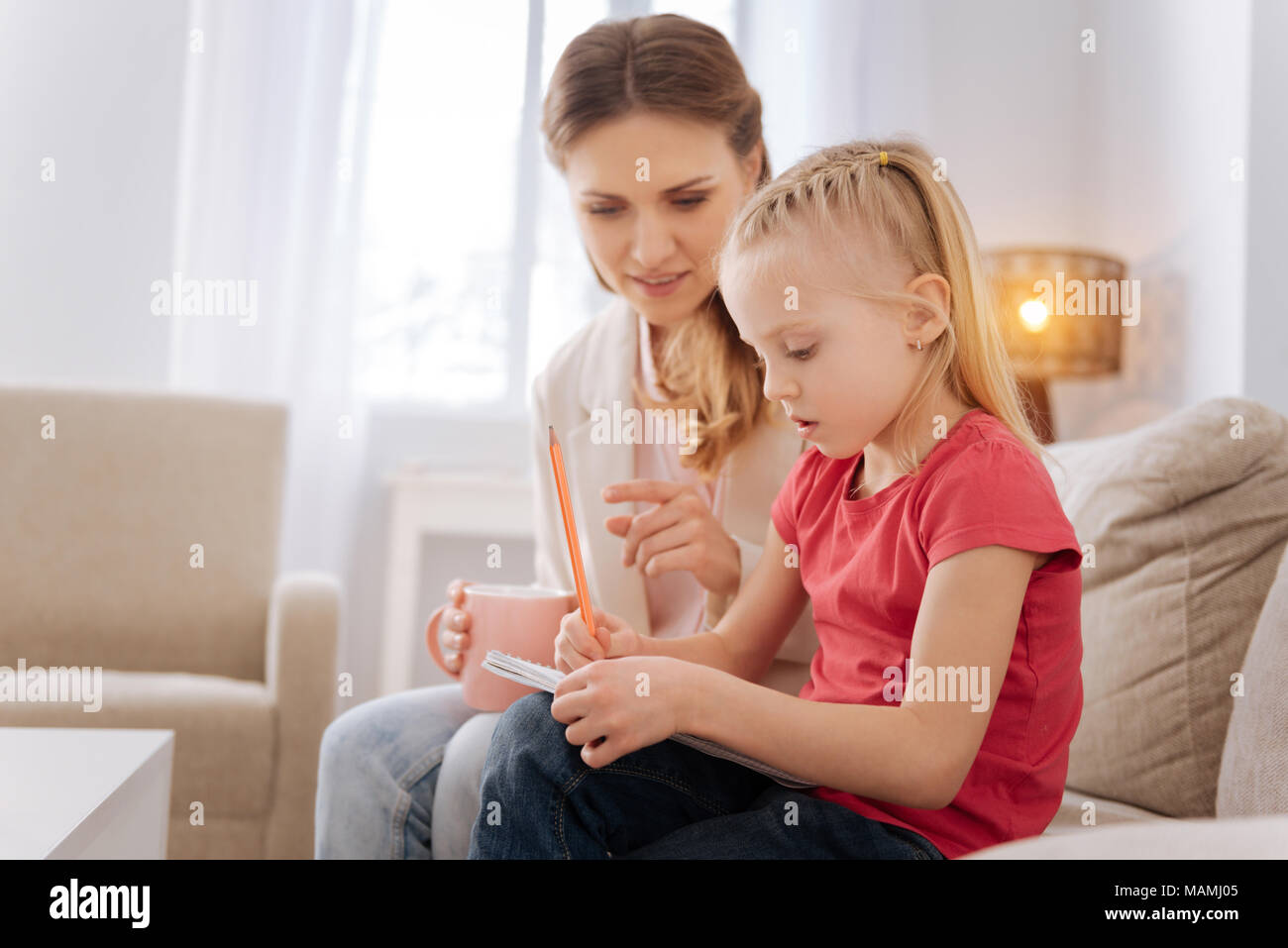 Serious intelligent girl doing a task Stock Photo - Alamy