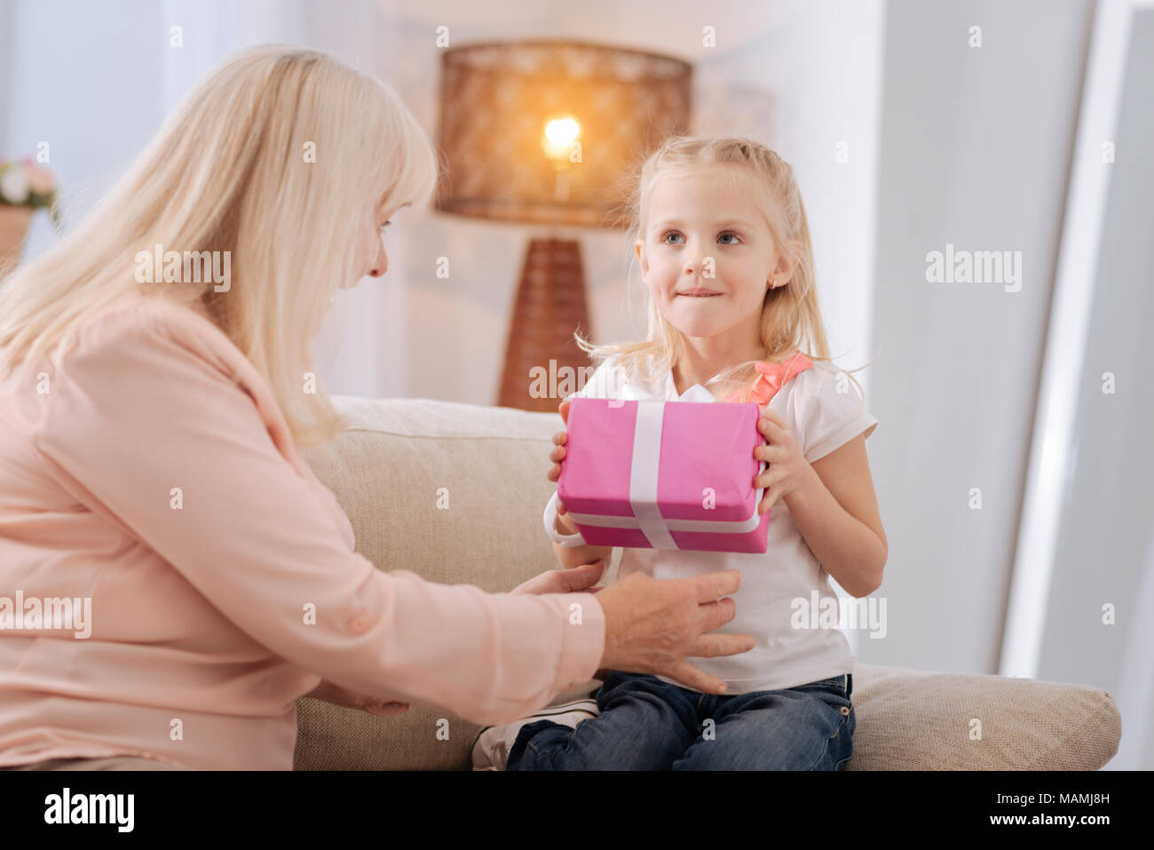 Joyful cute girl holding a gift box Stock Photo - Alamy