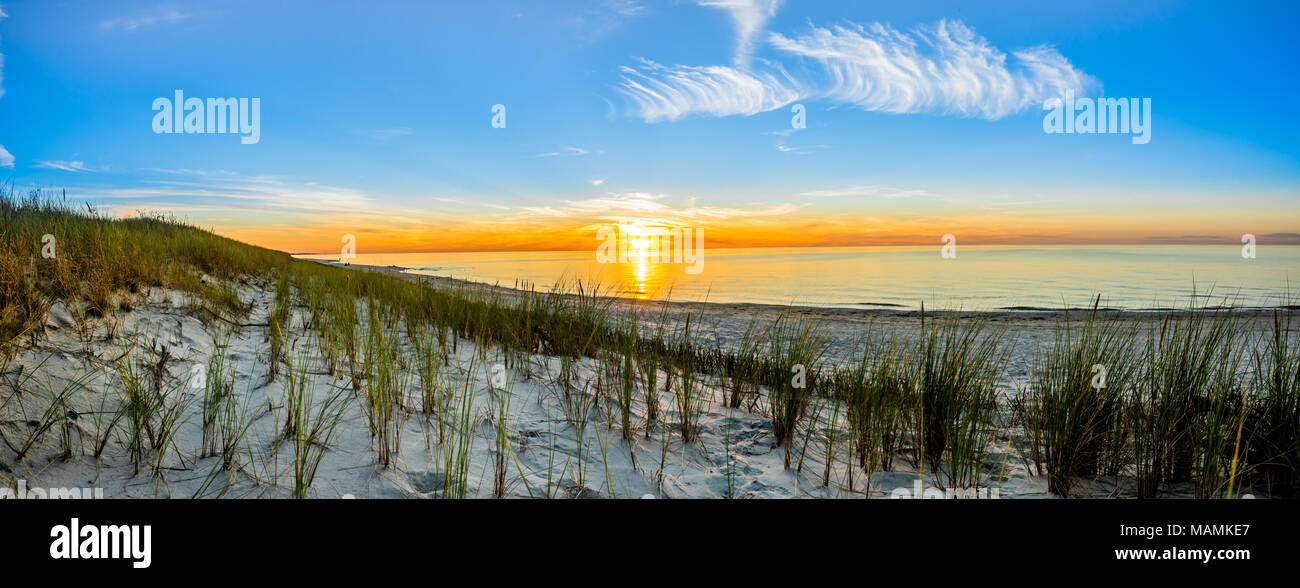Sandy beach and sunset sky with golden sun shining on white sand ...
