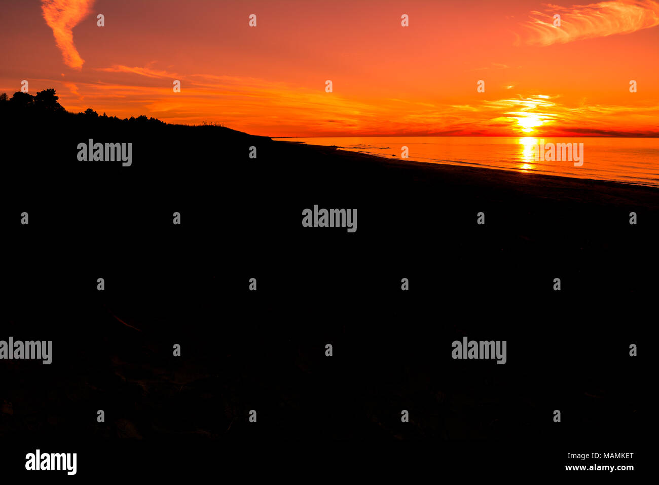 Silhouette of sunset beach, landscape of sky with red sun going in to ...