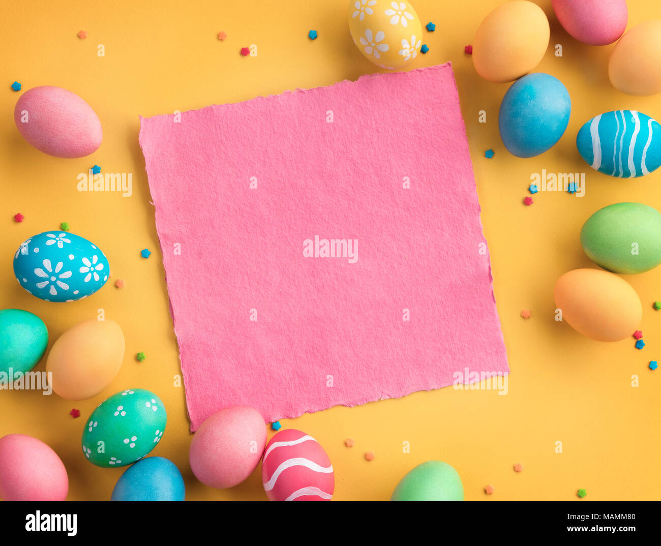 Happy Easter! Yellow background with colorful easter eggs. Top view ...