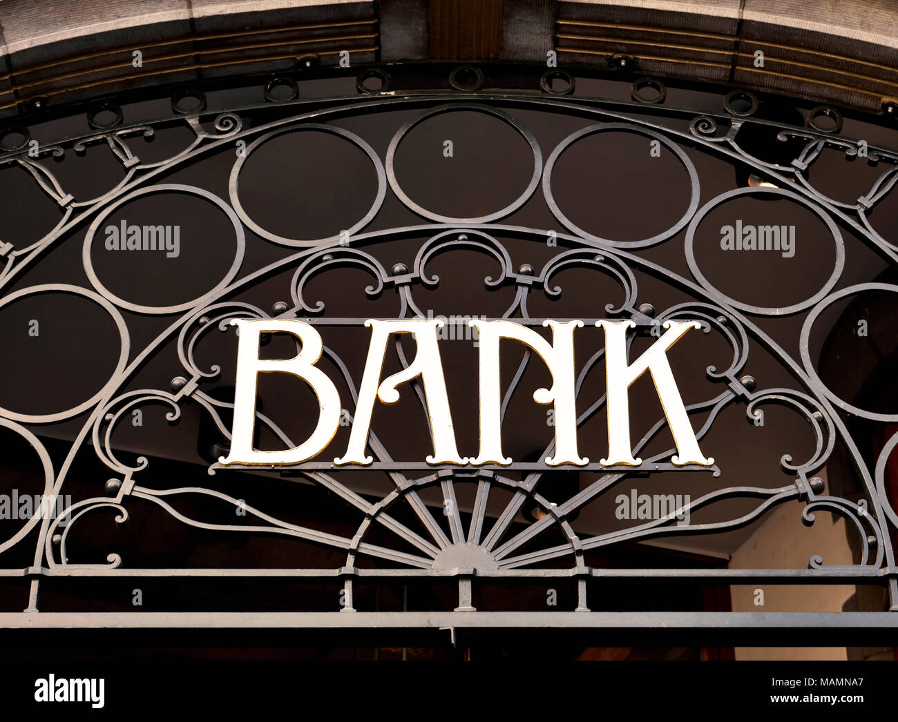 Bank building with wrought iron entrance and golden letters. Closeup ...