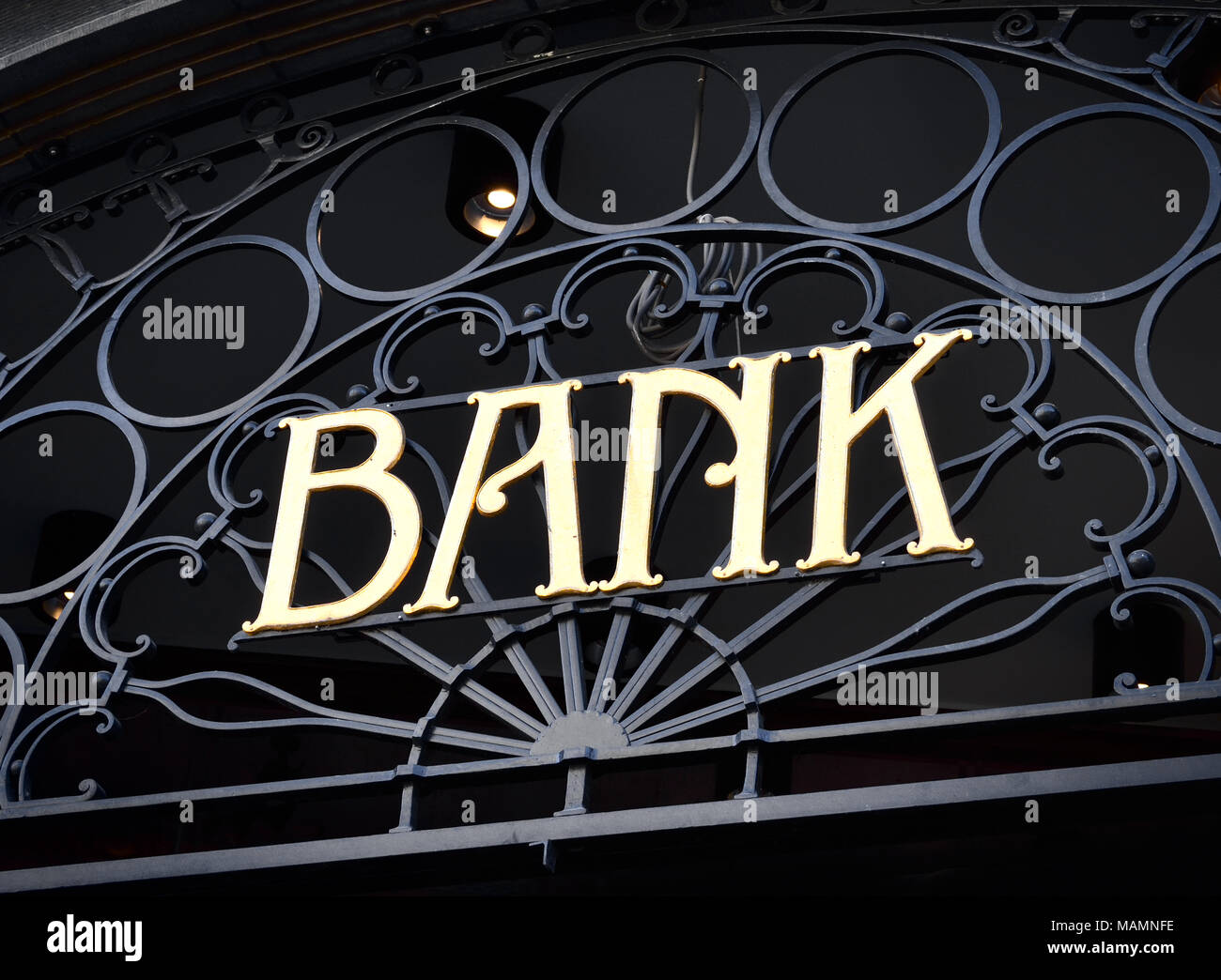Bank building with wrought iron entrance and golden letters. Closeup ...