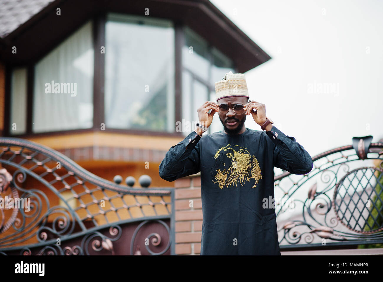 Rich african man in stylish traditional clothes and hat posed outdoor ...
