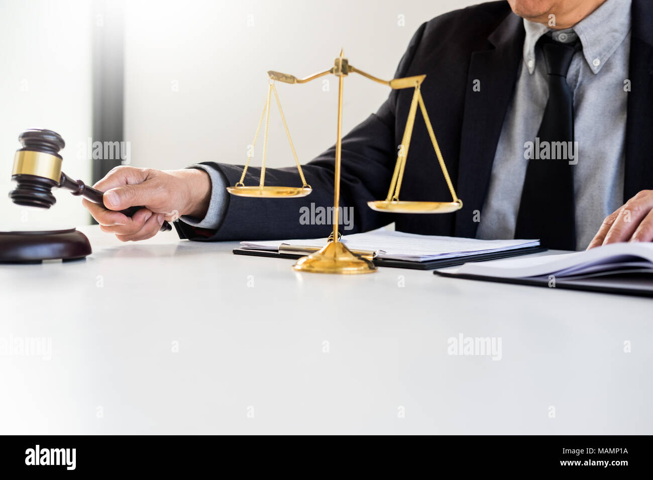 Male Judge lawyer In A Courtroom Striking The Gavel on sounding block ...