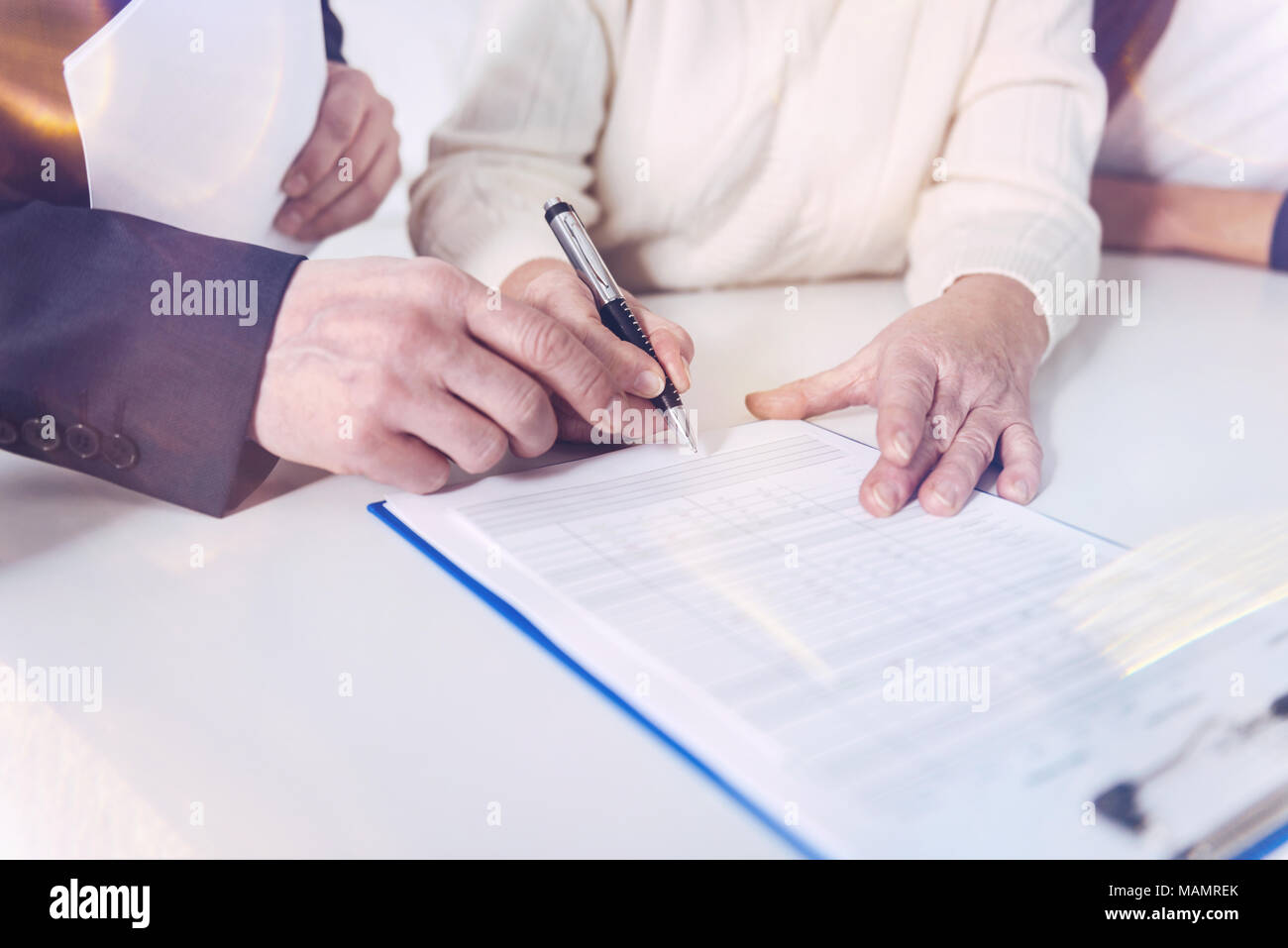 Aged pleasant woman signing insurance contract Stock Photo - Alamy