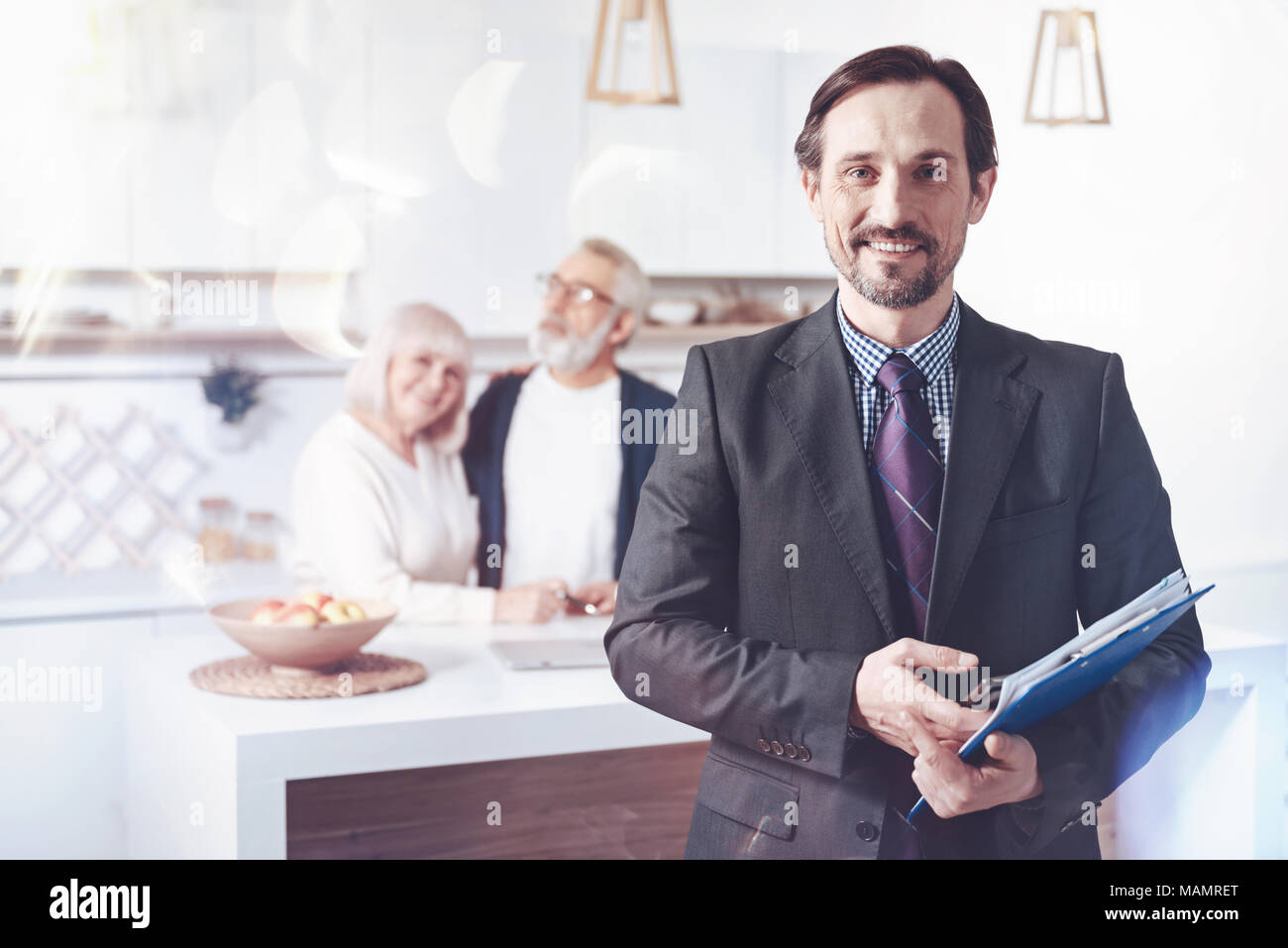 Professional smiling insurance agent working with elderly couple Stock ...