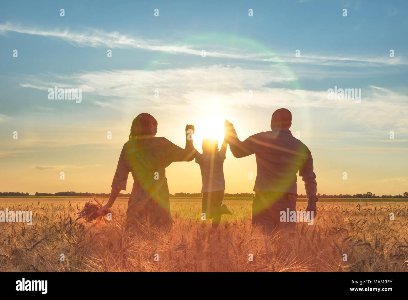 Happy family dad pregnant mom playing in the fresh air on the field ...