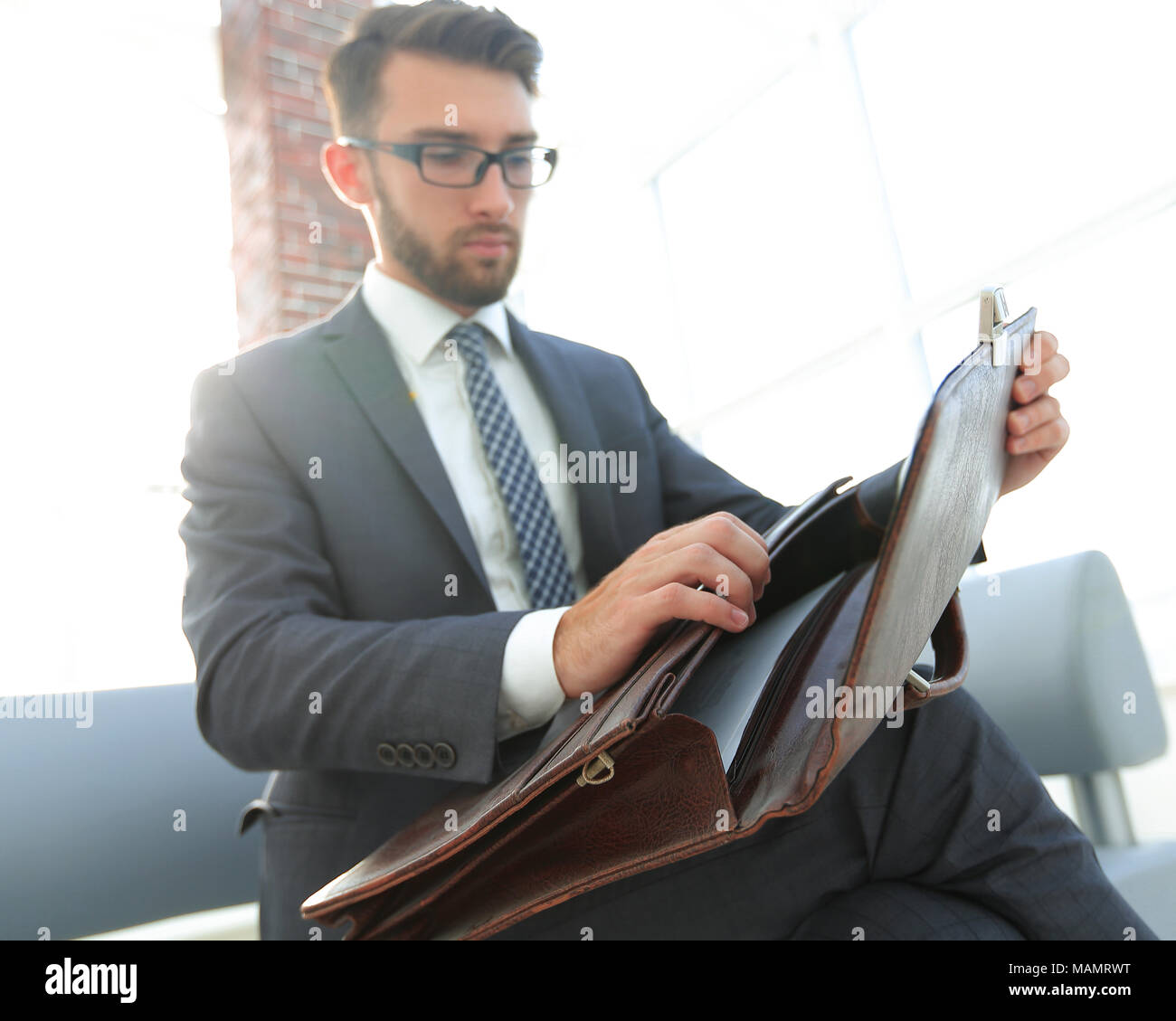 businessman's hand with suitecase in a modern office Stock Photo - Alamy
