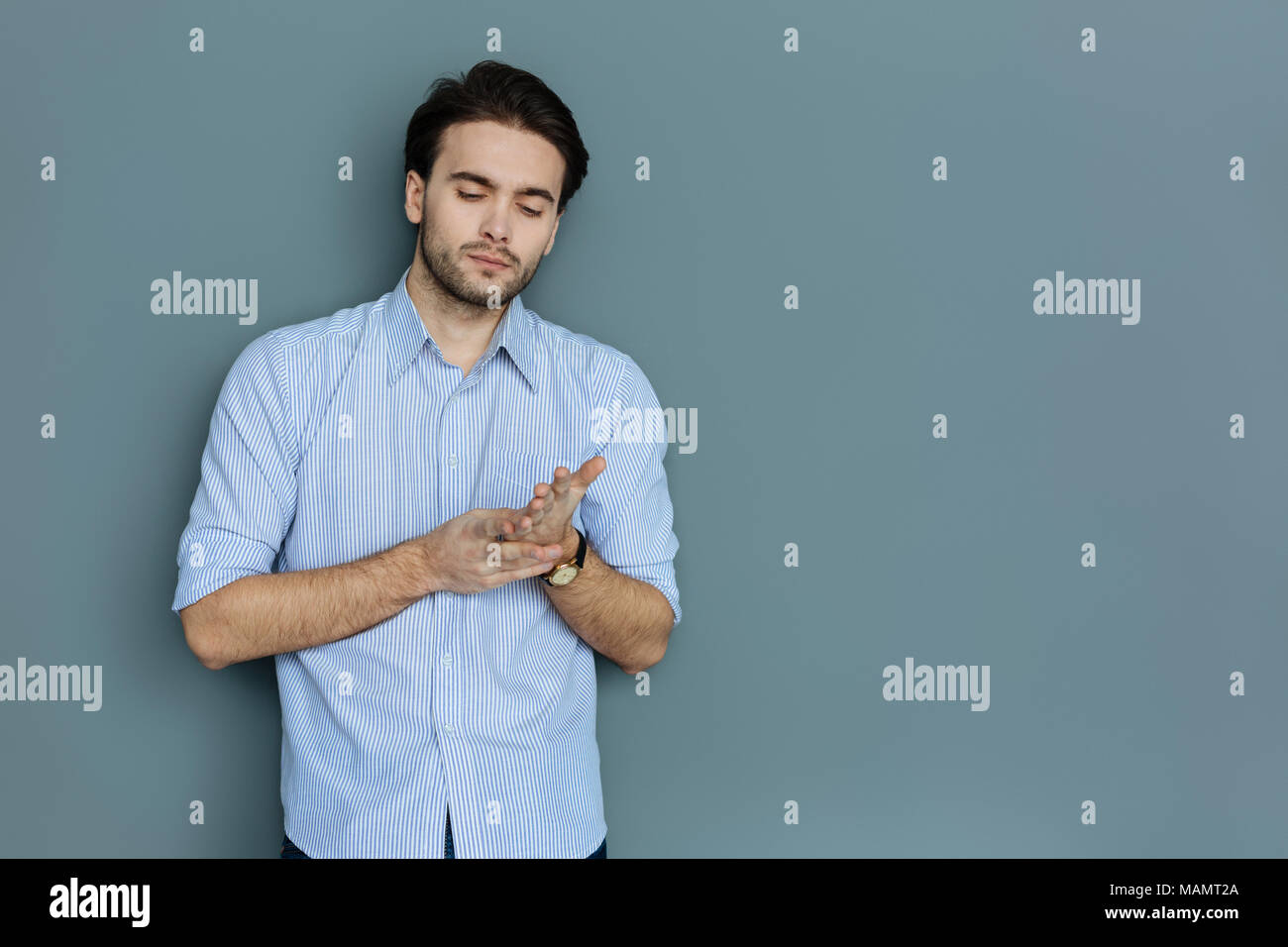 Nice thoughtful man touching his hand Stock Photo - Alamy
