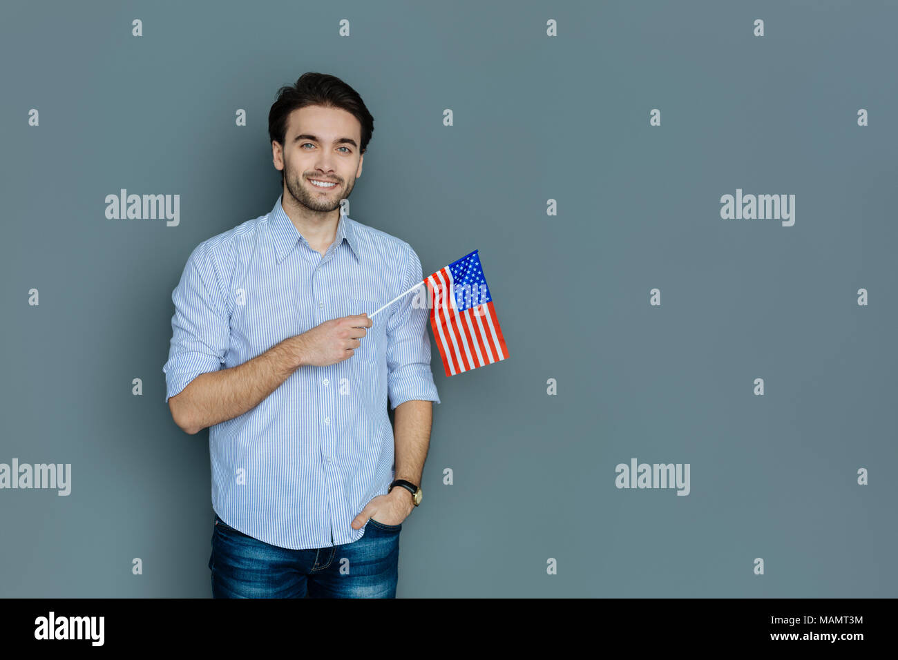Joyful patriotic man holding the US flag Stock Photo - Alamy