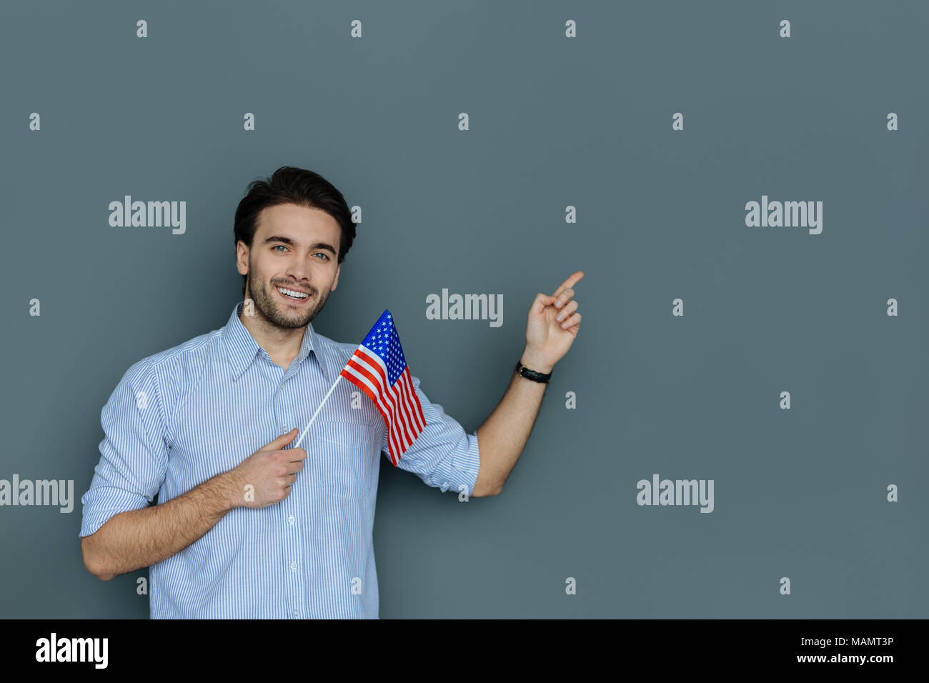 Cheerful happy man pointing with his hand Stock Photo - Alamy