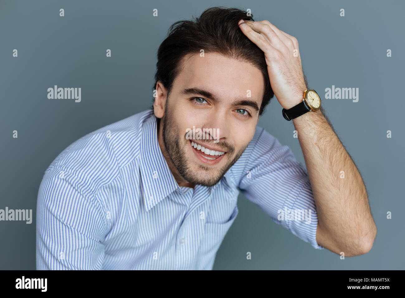 Portrait of a nice happy man touching his hair Stock Photo - Alamy