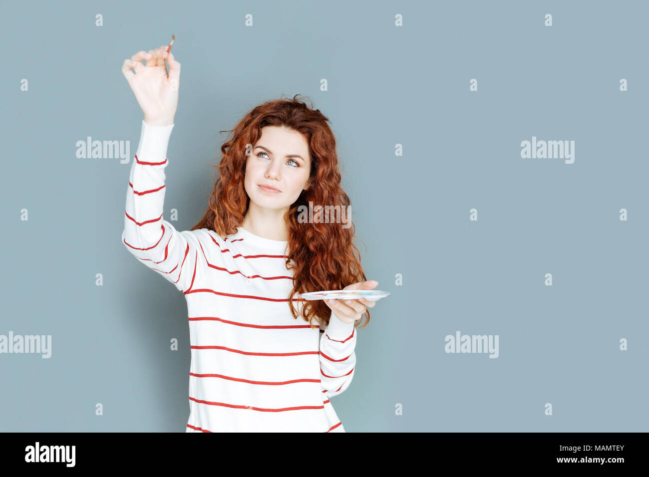 Delighted talented woman painting a portrait Stock Photo - Alamy