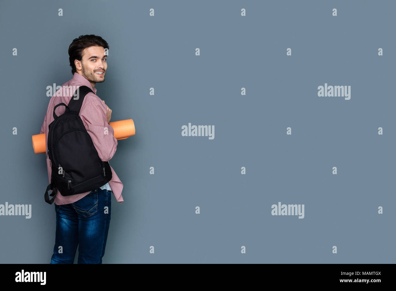 Joyful handsome man wearing rucksack Stock Photo - Alamy