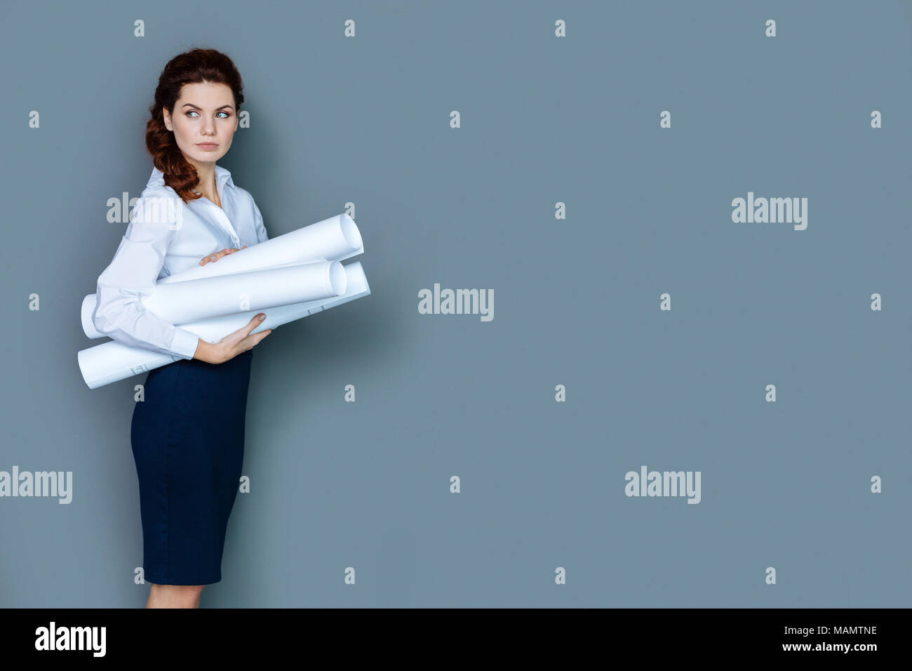 Smart nice woman holding blueprints Stock Photo - Alamy