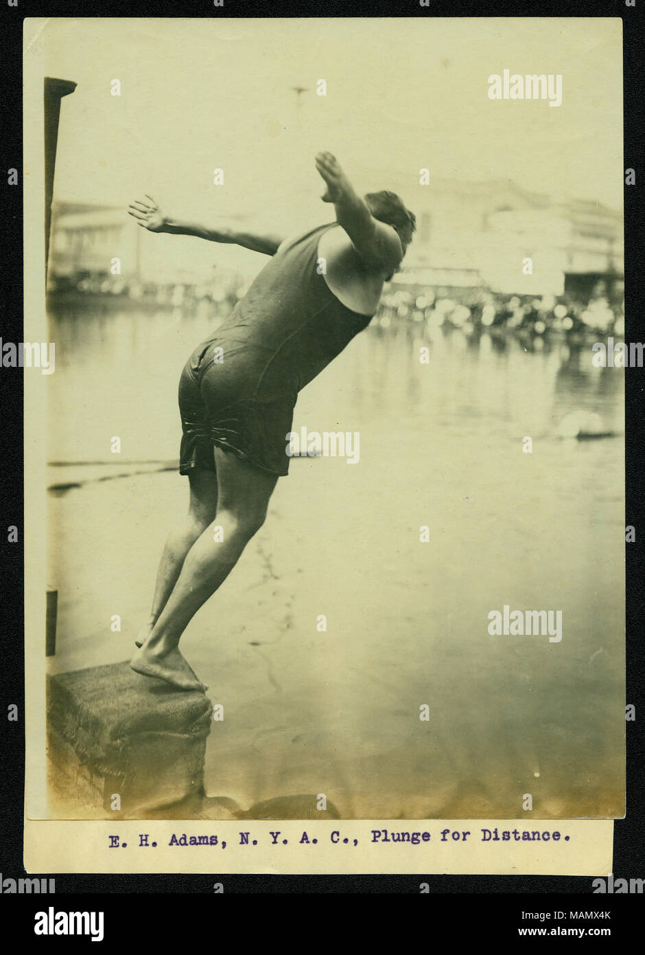 Vertical photograph of a man beginning to dive from a pillar into the ...