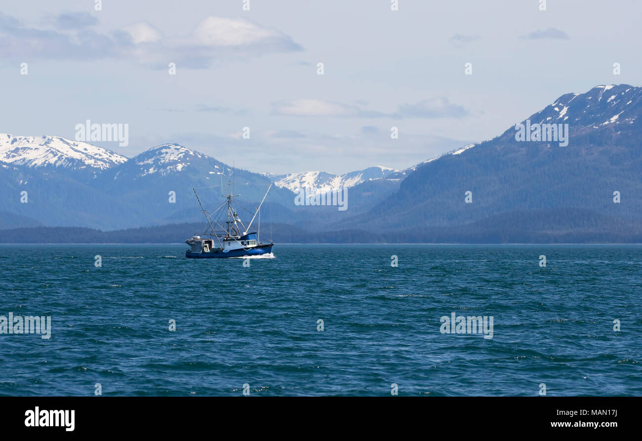 Salmon fishing boat in Lynn Canal in Southeast Alaska with mountains in ...