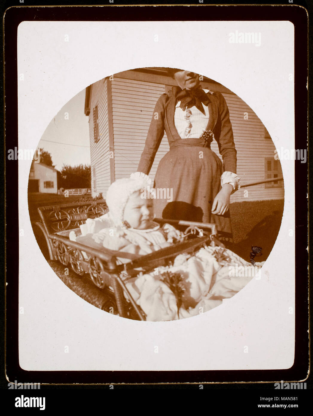 . English: Baby in carriage, woman standing behind . 1890/1900 Stock ...