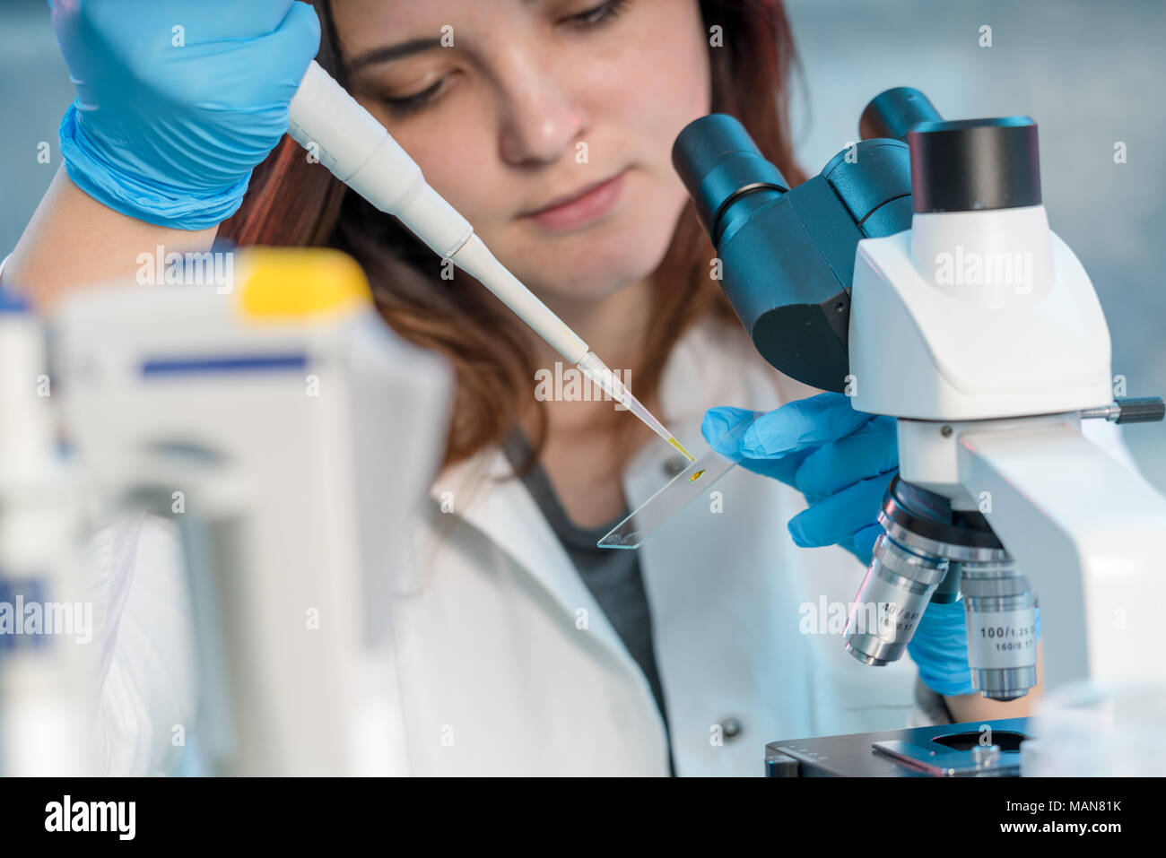 pretty female laboratory assistant analyzing a biological sample at ...