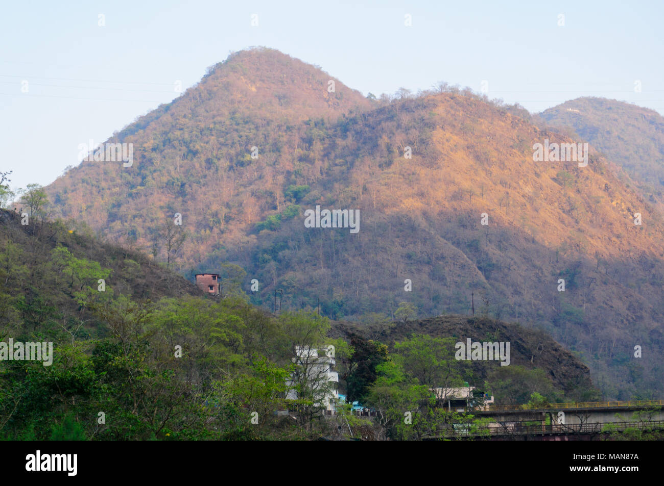 Mountains and hills with trees covering them and buildings. Shot in ...