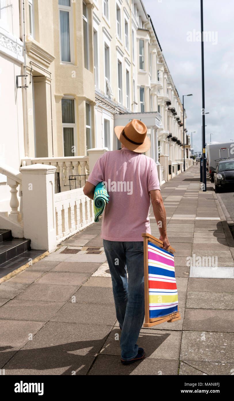 Single man walking alone searching for accommodation at a seaside ...