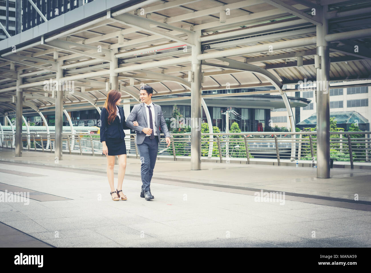 Business people walking through passage office. Smiling to each other ...