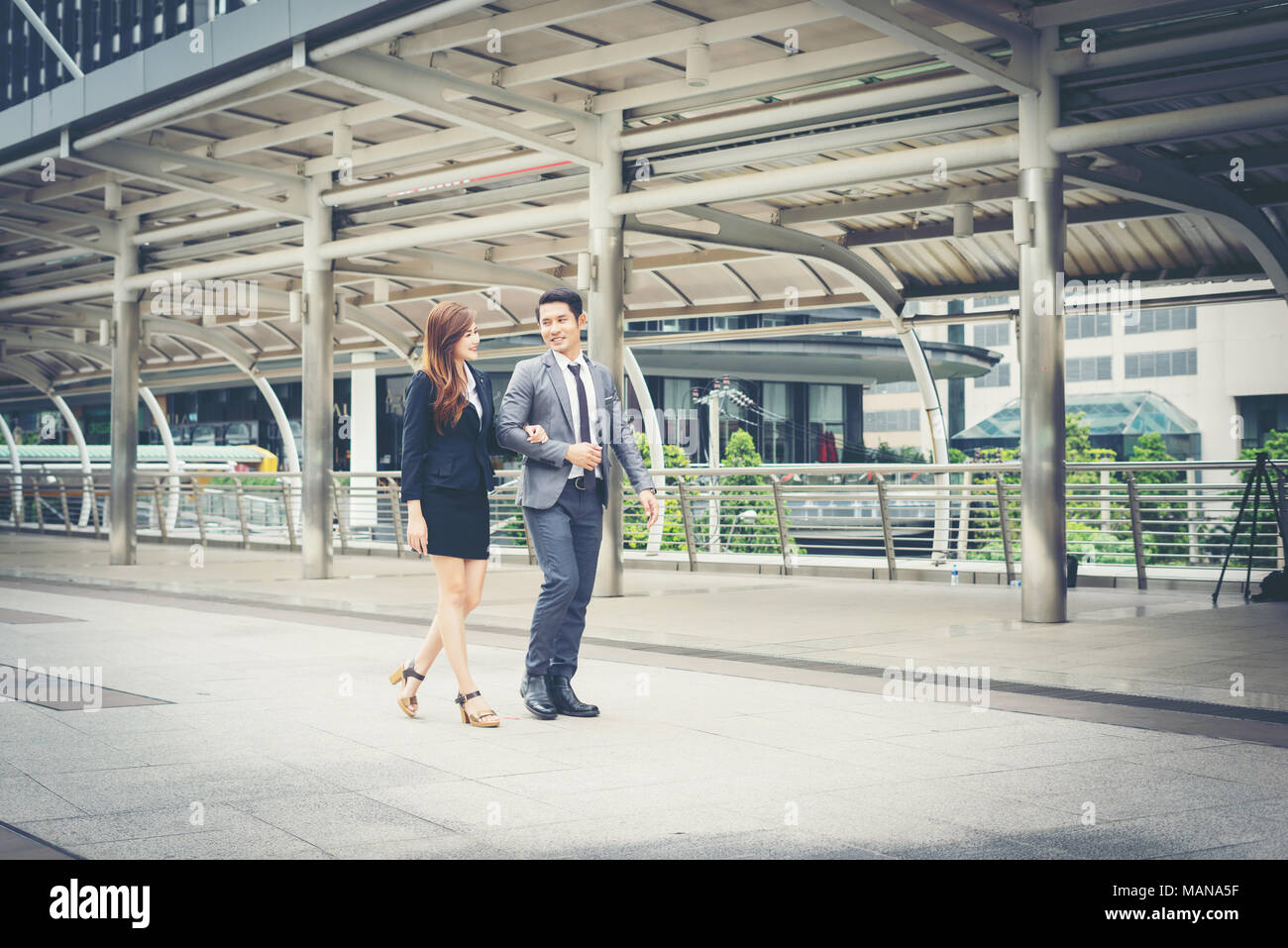 Business people walking through passage office. Smiling to each other ...