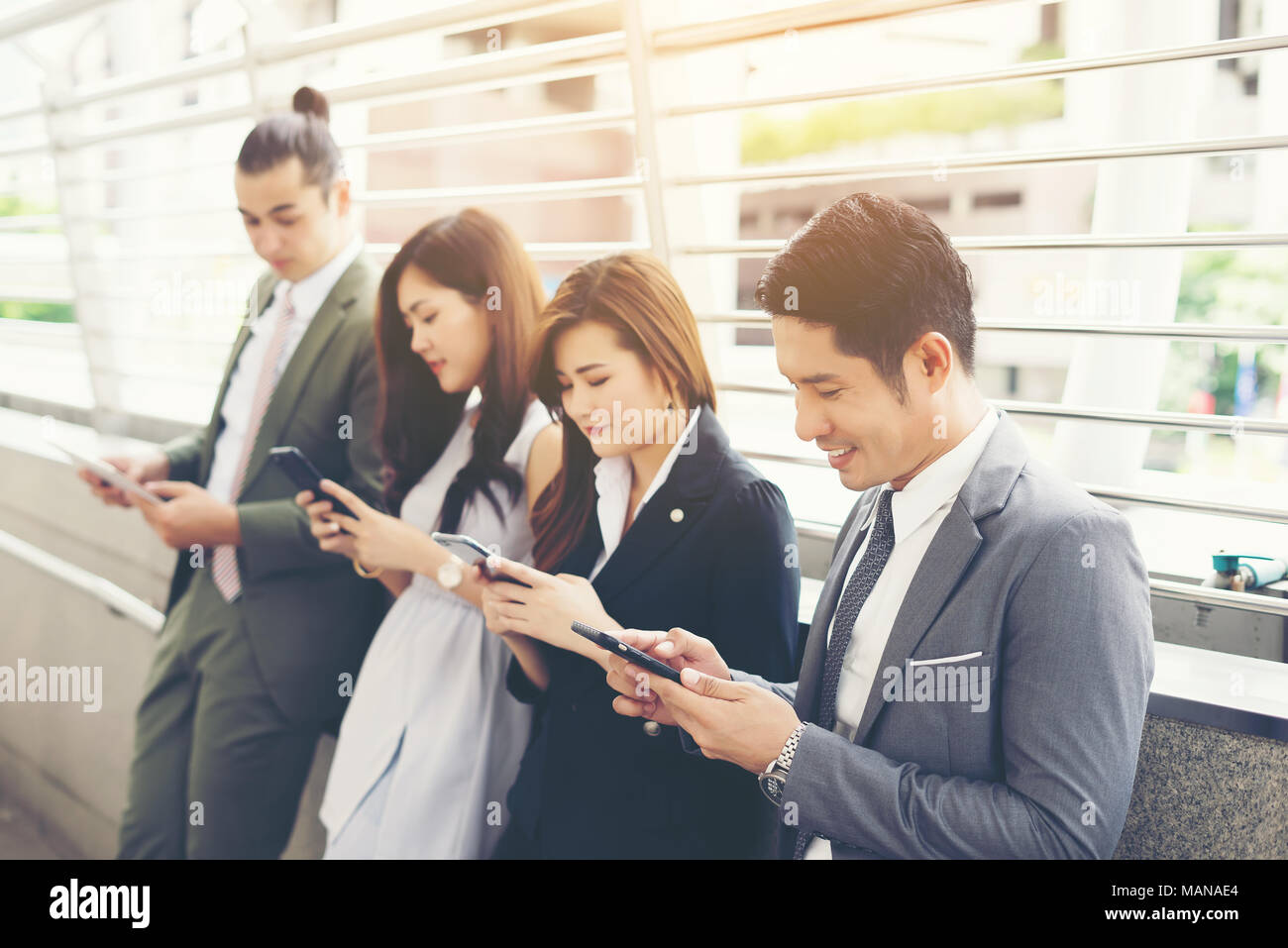 Business people using smartphone while together Stock Photo - Alamy