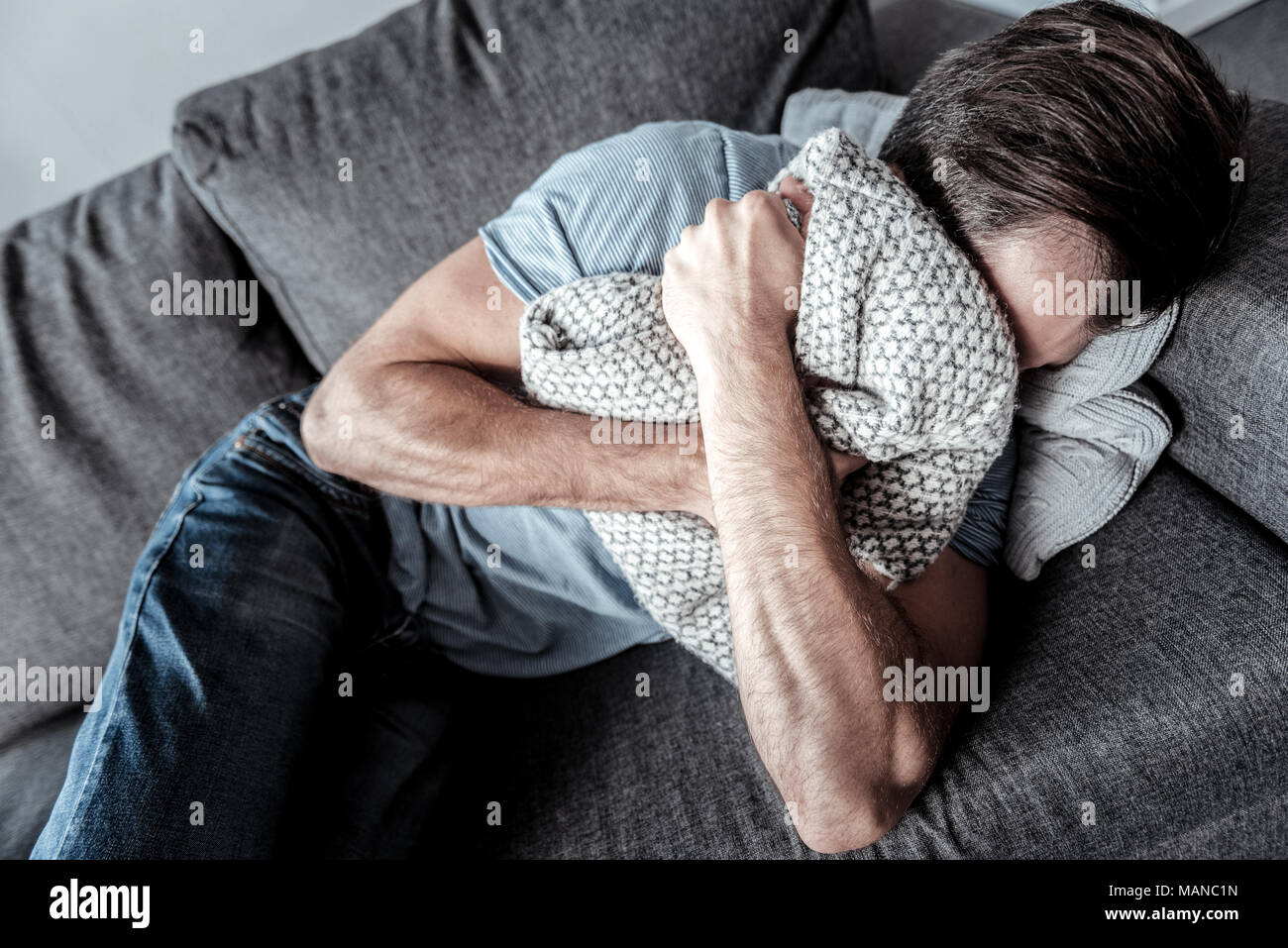 Cheerless sad man crying in the cushion Stock Photo - Alamy