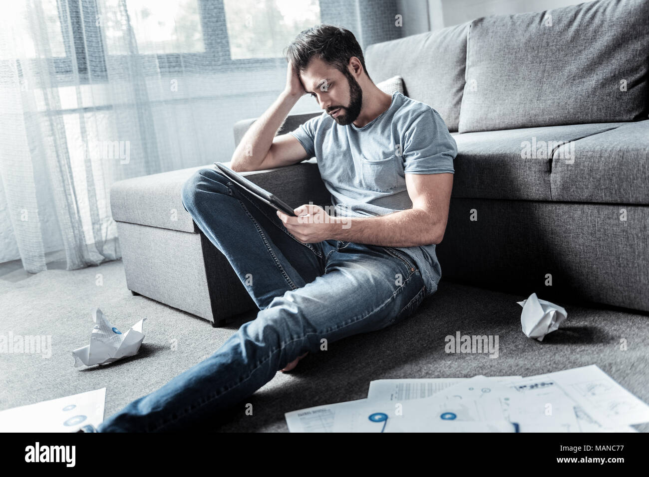 Sad moody man sitting on the floor Stock Photo - Alamy