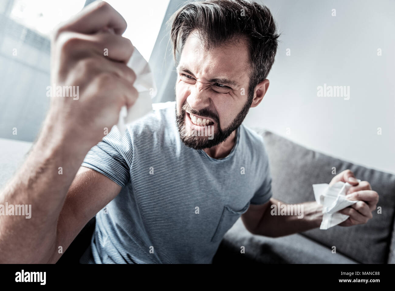 Angry young man crumpling paper Stock Photo - Alamy