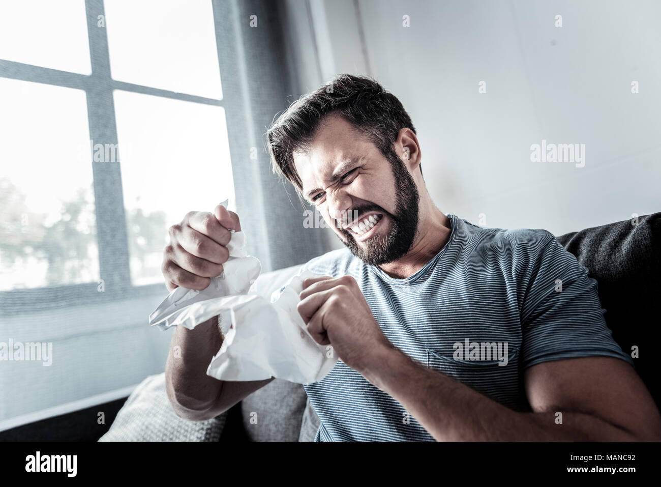 Hysteric emotional man tearing up paper Stock Photo - Alamy