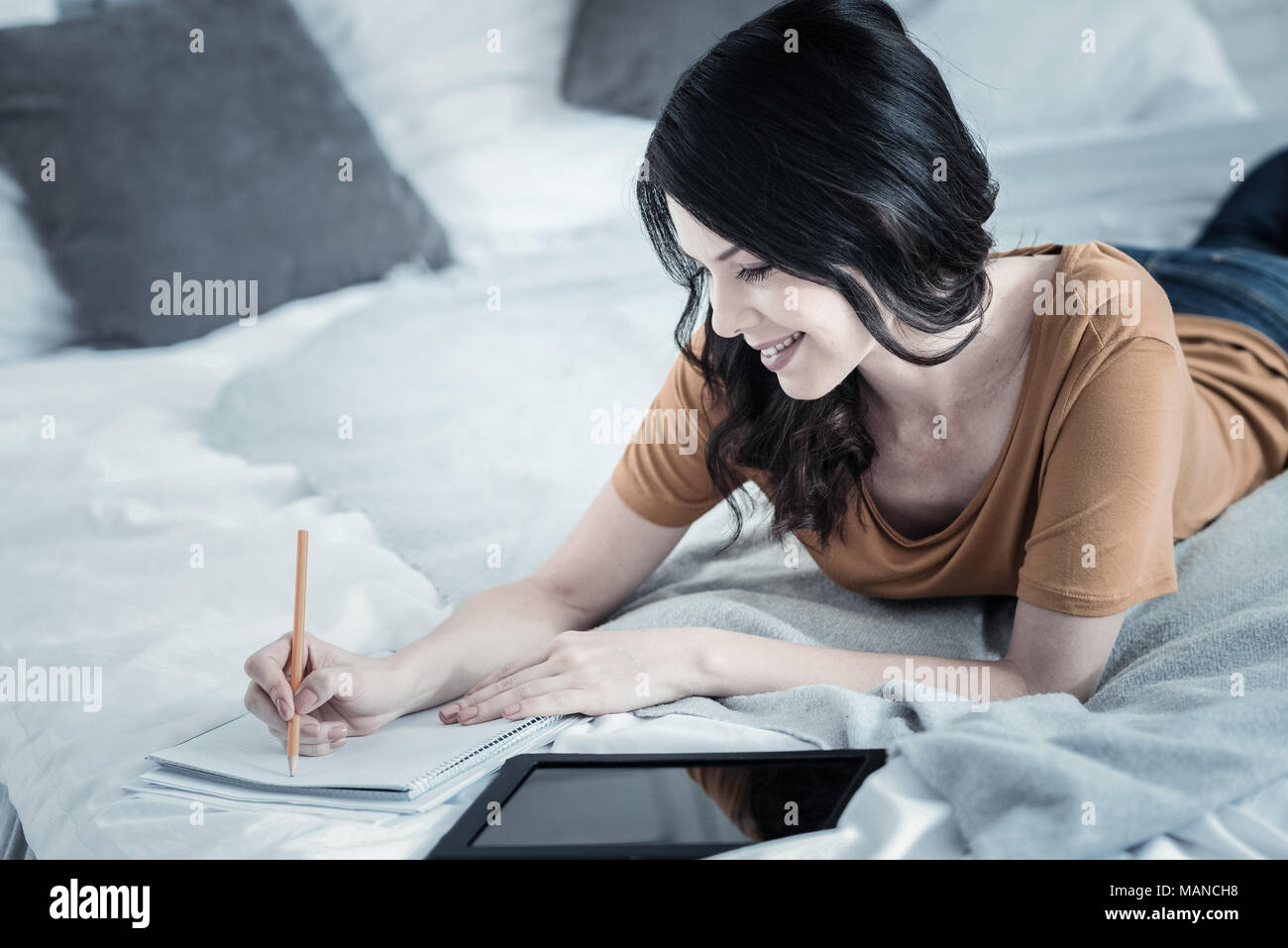 Positive cheerful woman noting down her ideas Stock Photo - Alamy