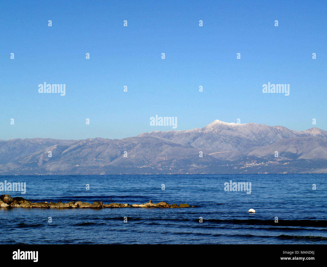 View of snow covered Albanian mountains and coast from Roda, Corfu ...