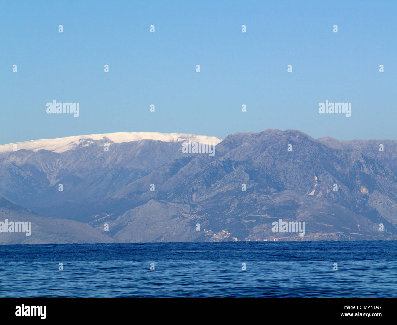 View of snow covered Albanian mountains and coast from Roda, Corfu ...