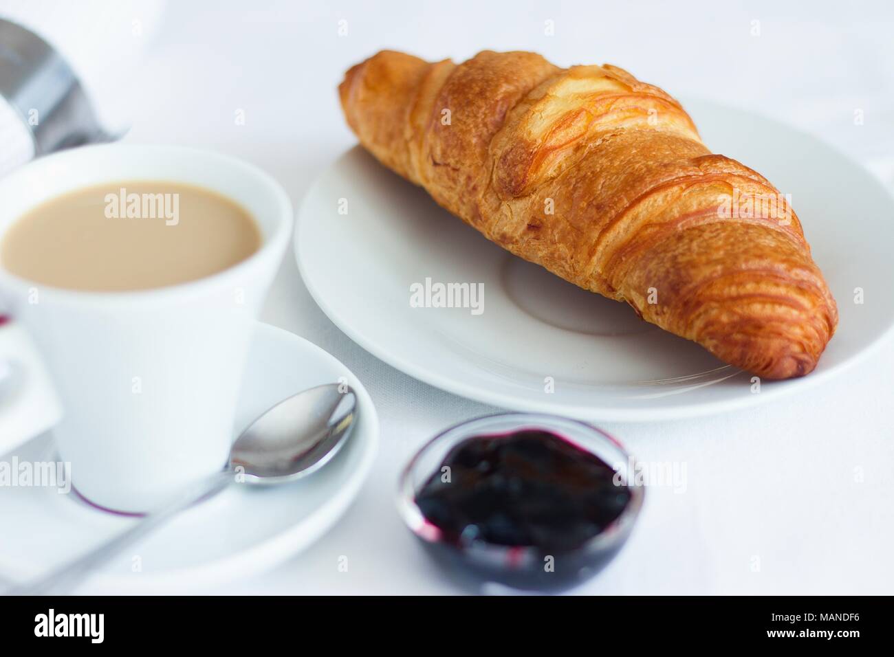 Croissant with butter, blueberry jam and a cup of coffee. Perfect ...