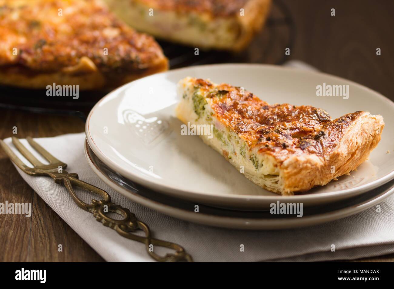 Triangle shaped piece of vegetable pie, or quiche, served on a plate ...